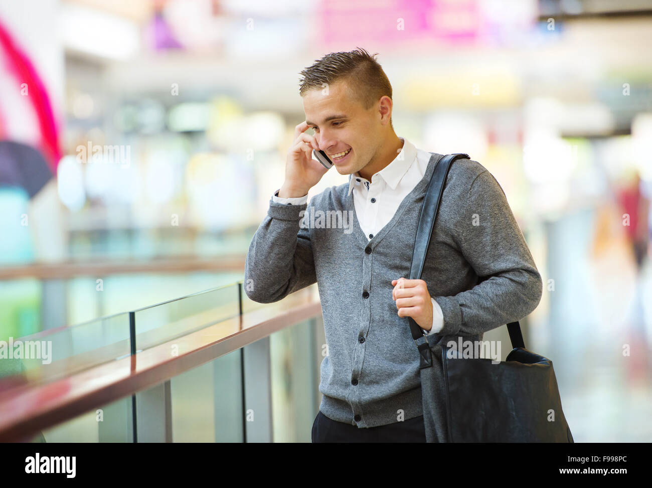 Handsome young man in shopping mall using mobile phone Stock Photo - Alamy
