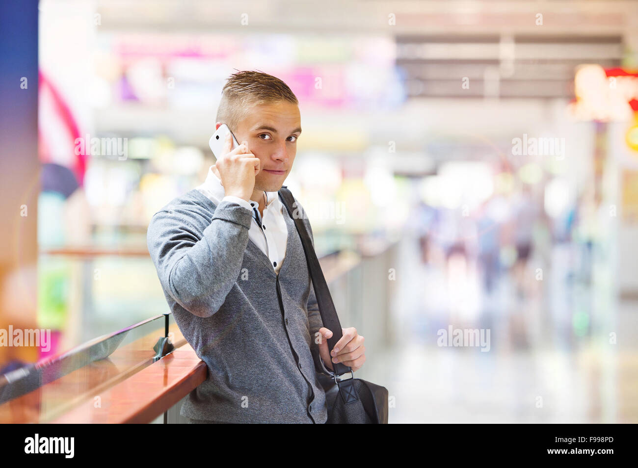 Handsome young man in shopping mall using mobile phone Stock Photo - Alamy