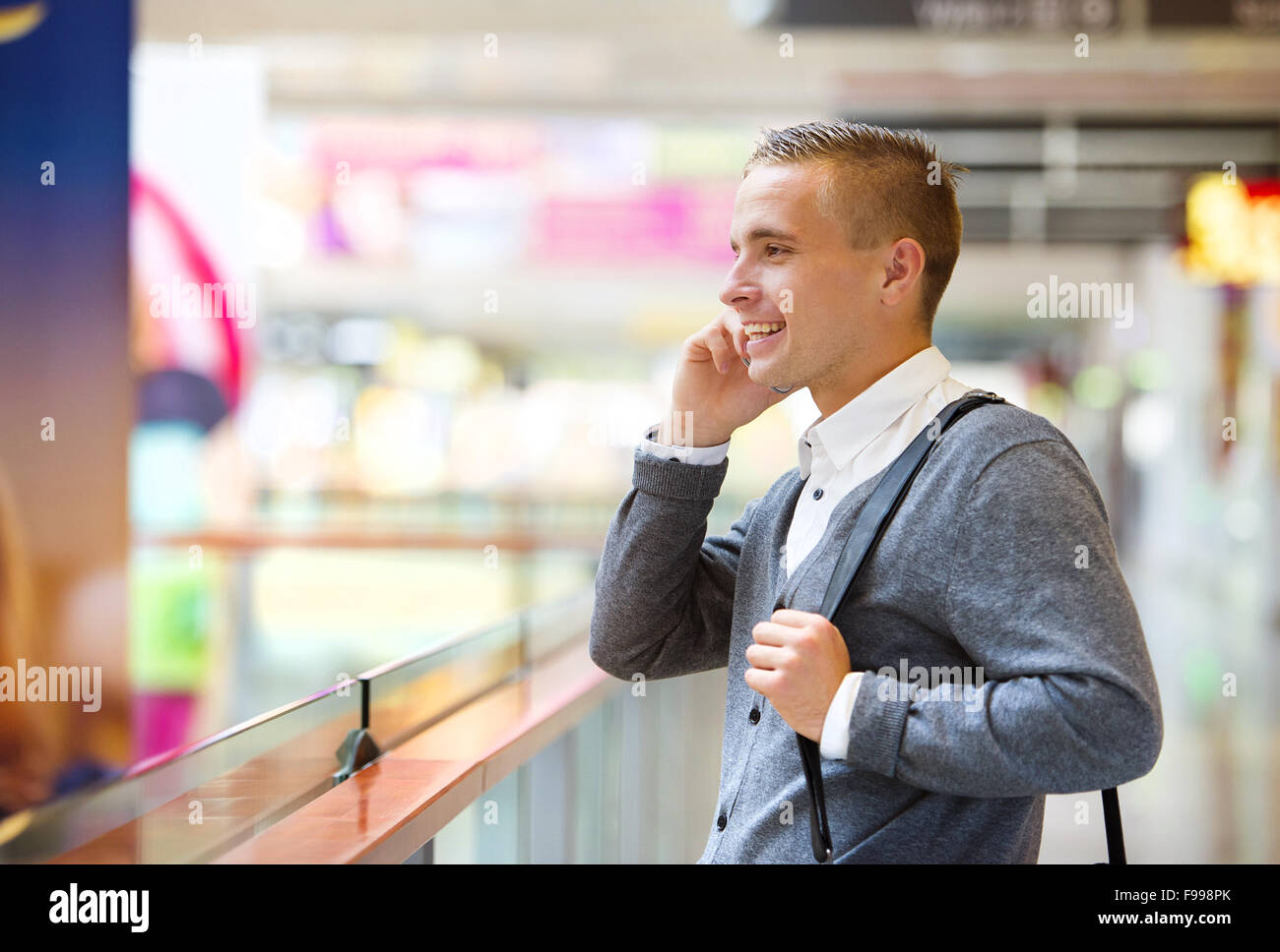 Handsome young man in shopping mall using mobile phone Stock Photo - Alamy