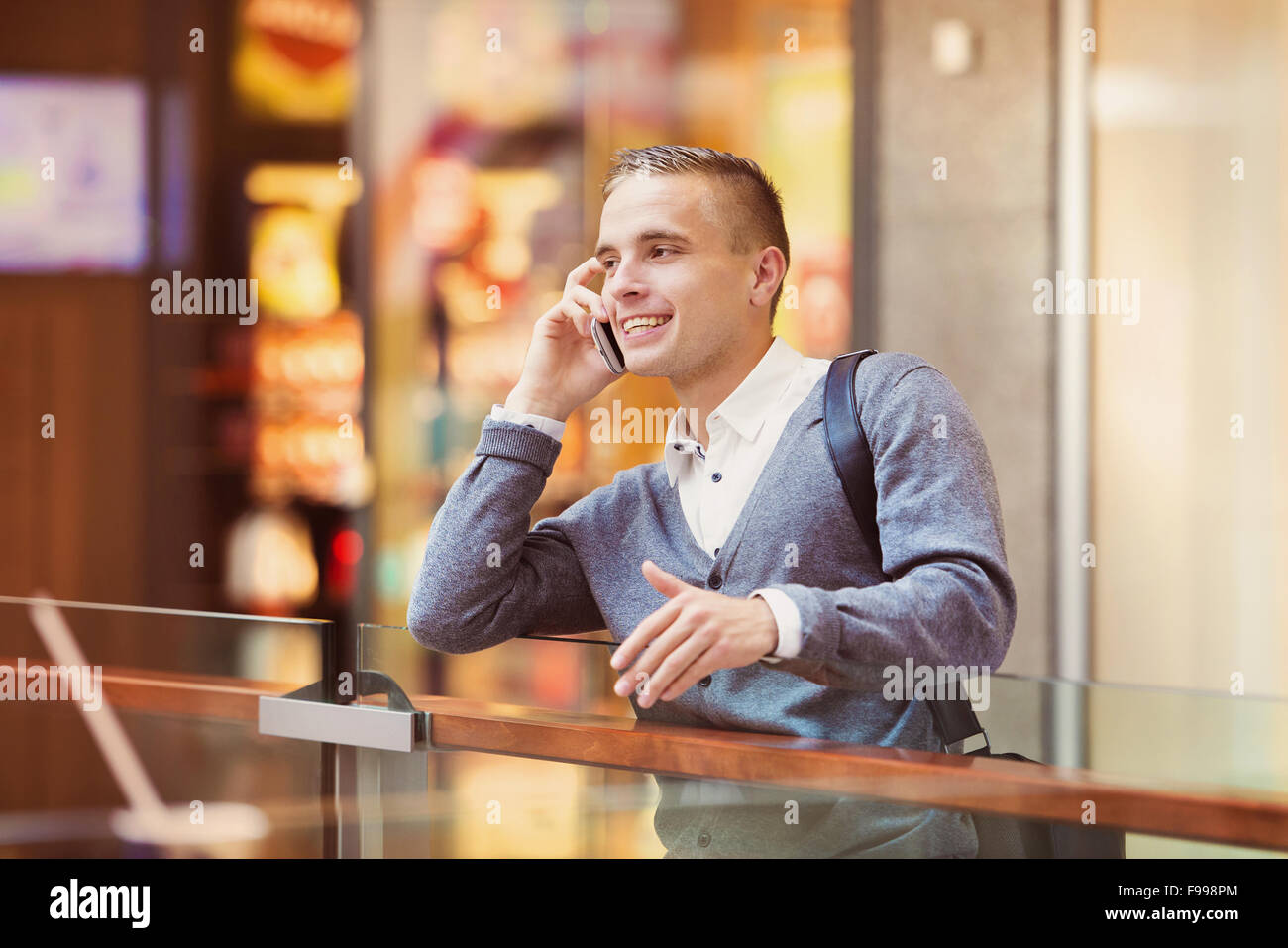 Handsome young man in shopping mall using mobile phone Stock Photo - Alamy