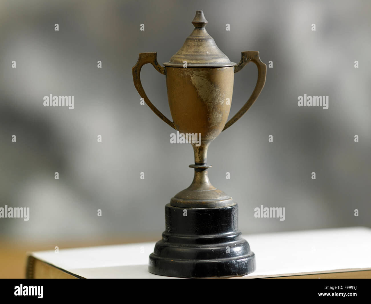 old trophy on stack of book Stock Photo - Alamy