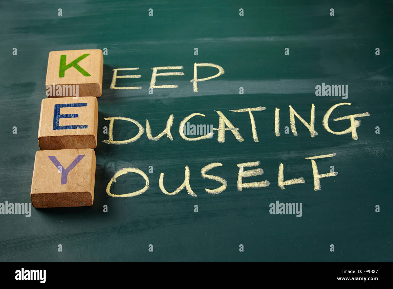 KEEP EDUCATING YOURSELF. Educational concept with wood block and chalk ...