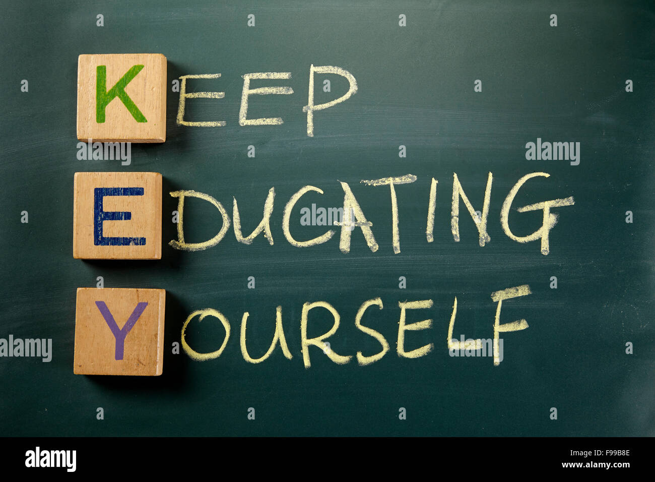 KEEP EDUCATING YOURSELF. Educational concept with wood block and chalk ...