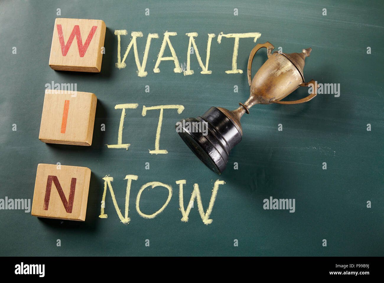 Hand writing WIN- Want it now written with chalk on blackboard Stock ...