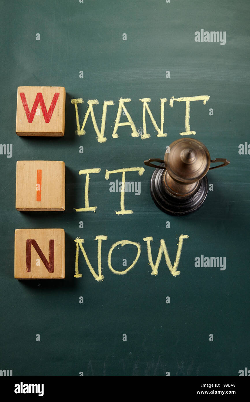 Hand writing WIN- Want it now written with chalk on blackboard Stock ...