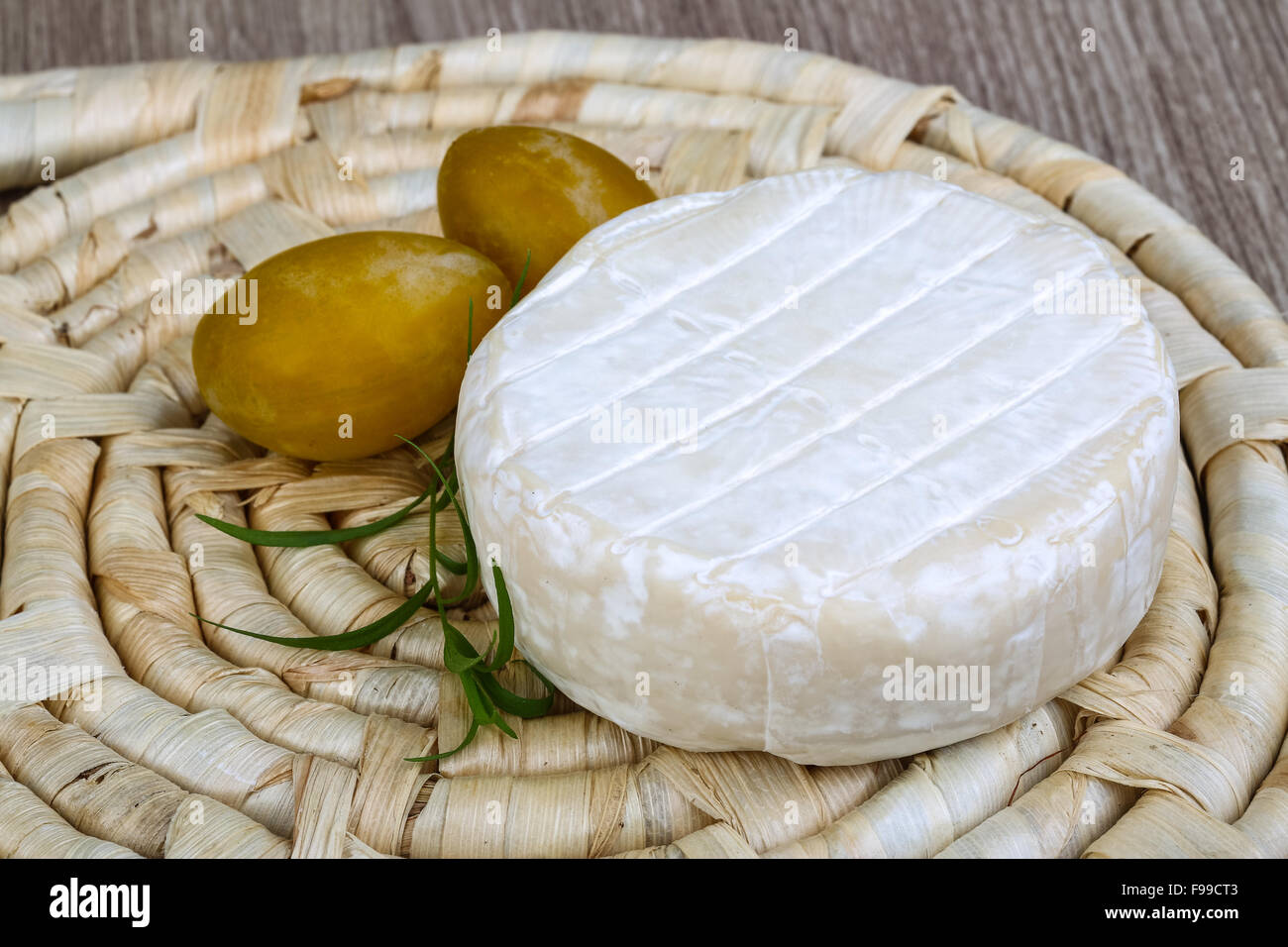 Round Brie cheese with yellow plums and estragon Stock Photo - Alamy