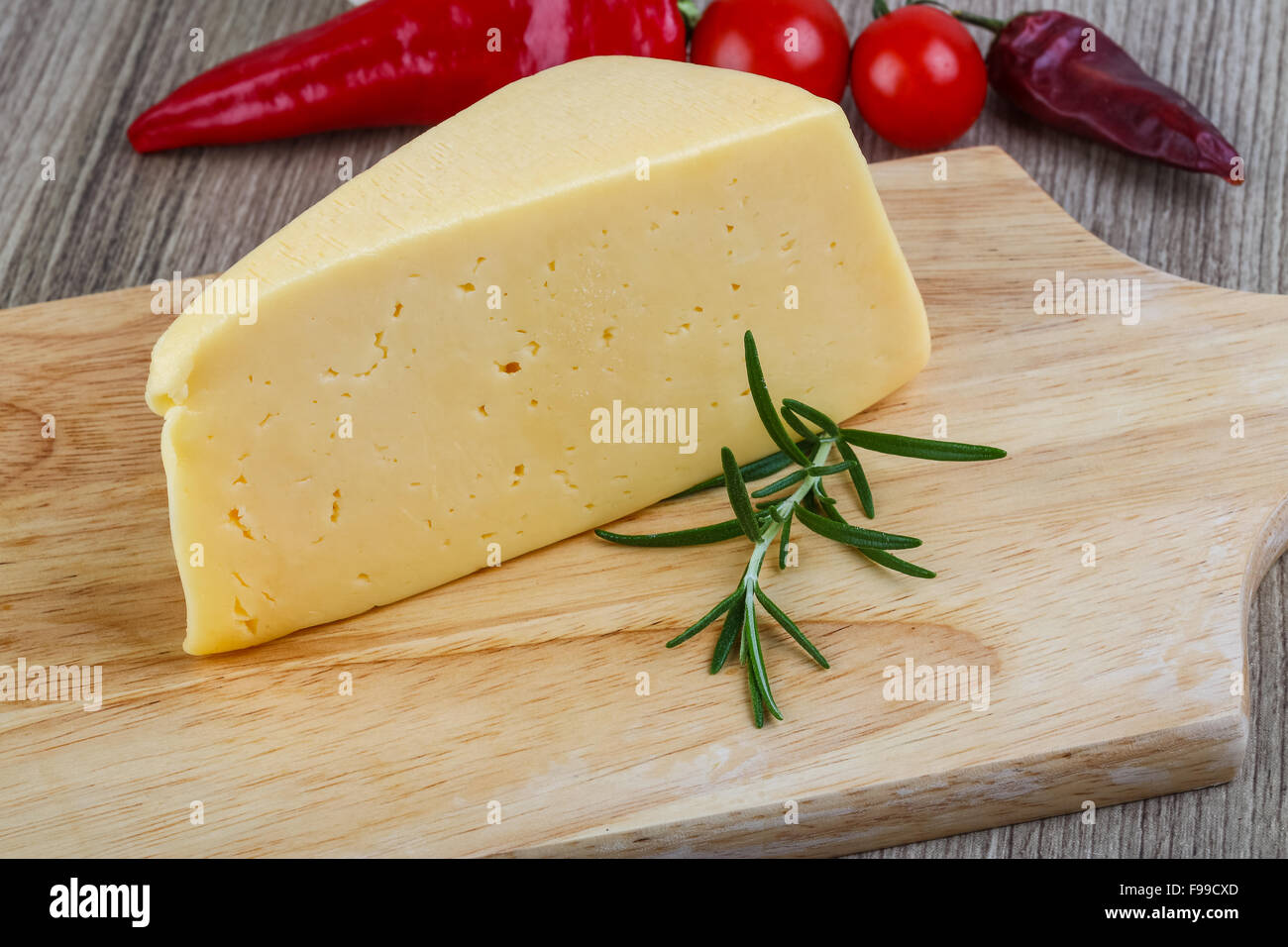 Yellow cheese triangle with rosemary herbs on the wood background Stock ...