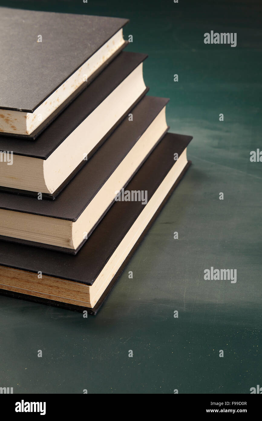 stack of books on the blackboad Stock Photo - Alamy