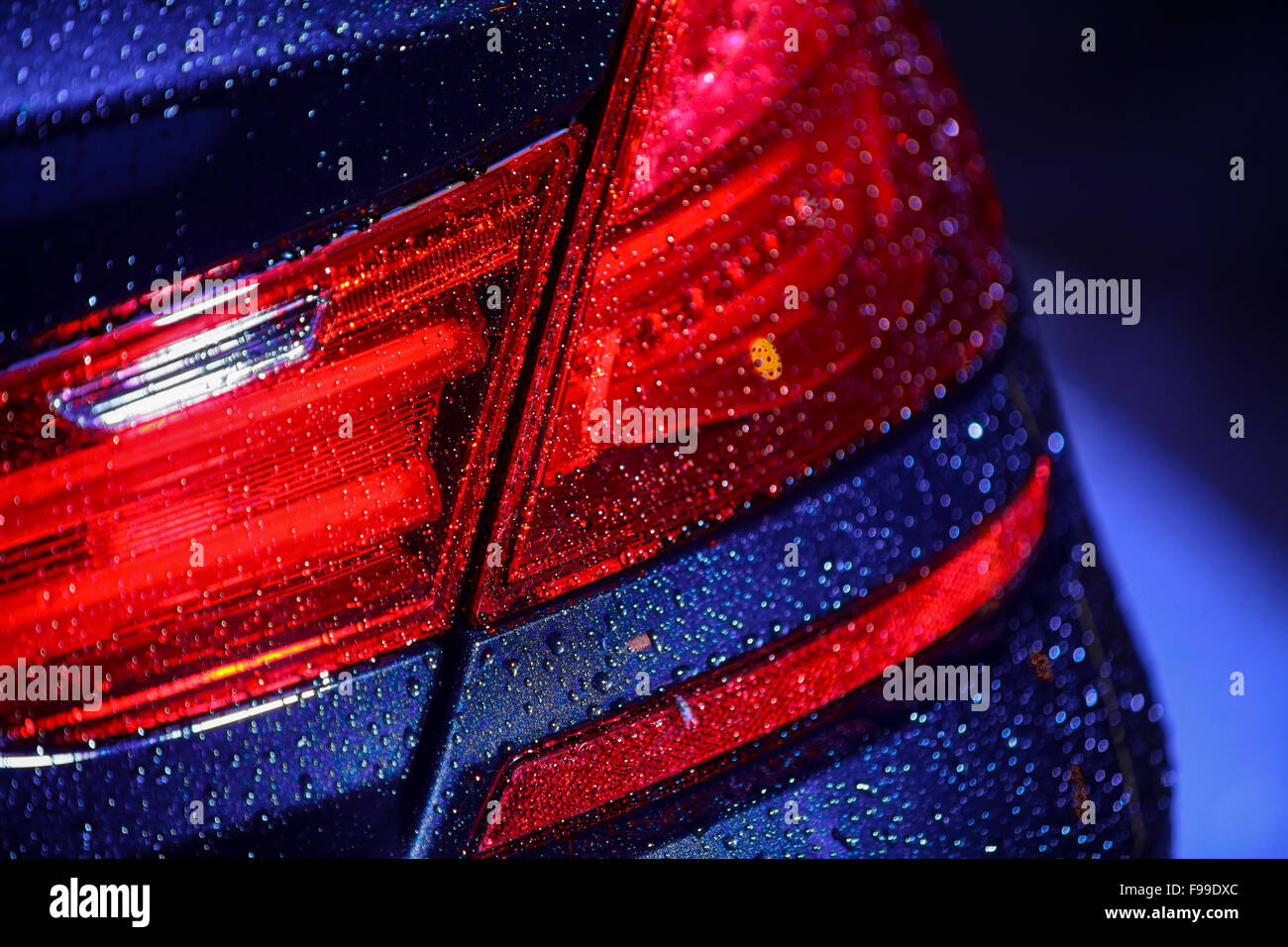Color image with a car's rear brake light, covered with rain drops ...