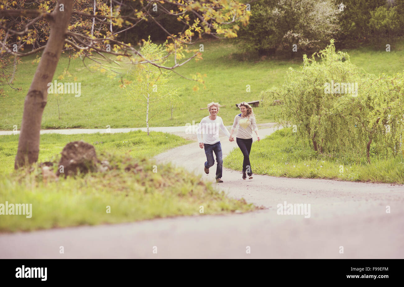 Young beautiful couple taking a walk in green park Stock Photo - Alamy