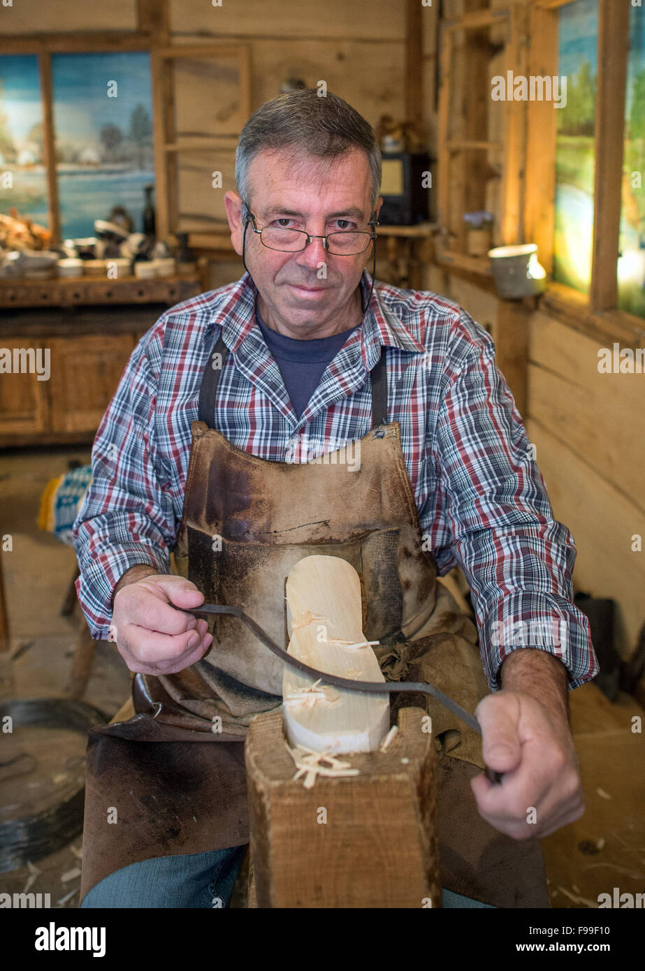 Clog maker Manfred Karolczak works with a drawknife on a wooden shoe ...