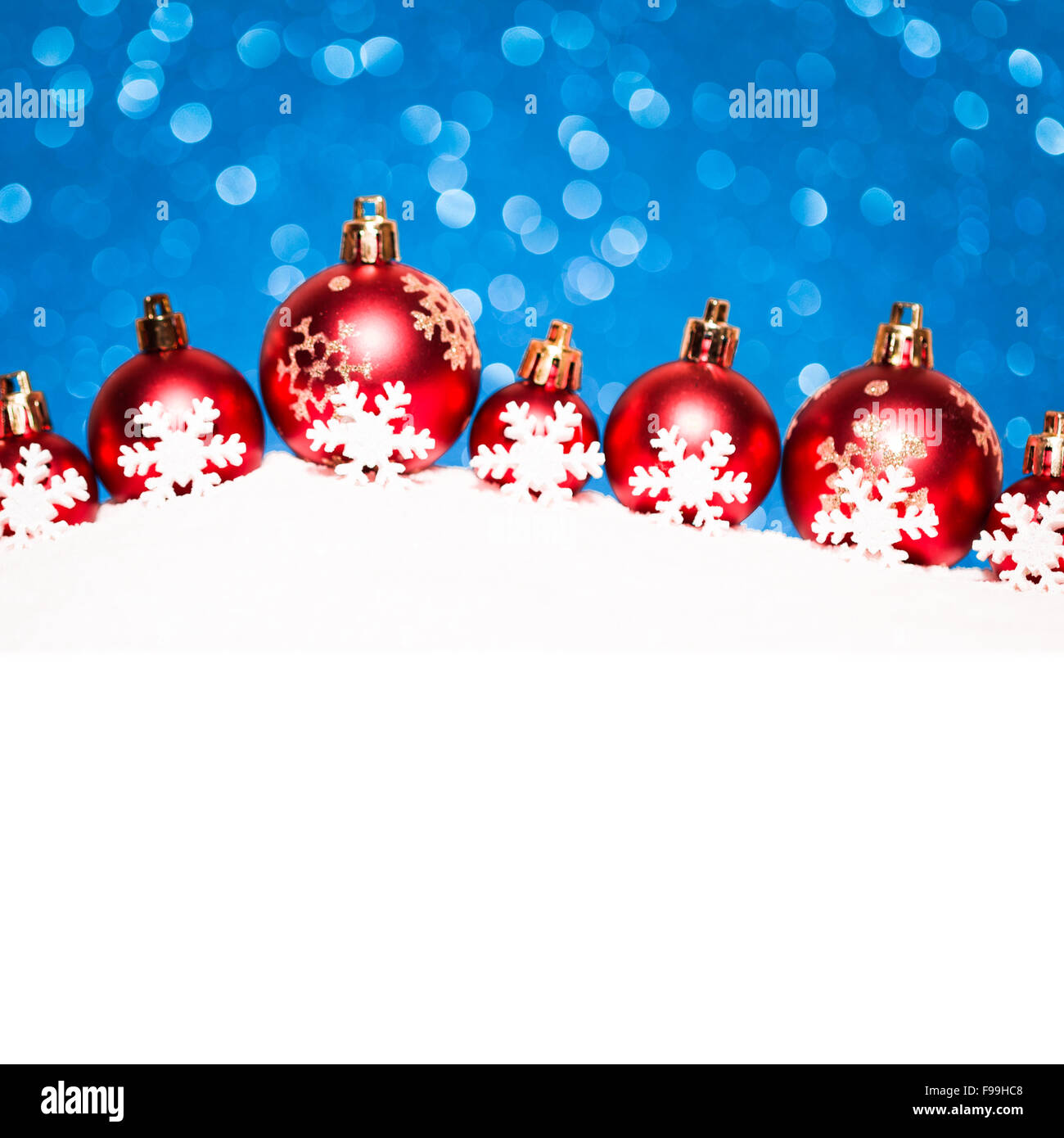 christmas red balls in snow on blue glitter background Stock Photo - Alamy