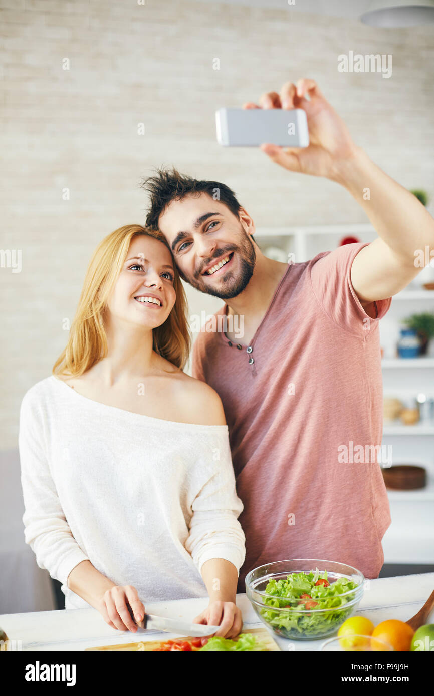 Affectionate couple cooking and making selfie Stock Photo - Alamy
