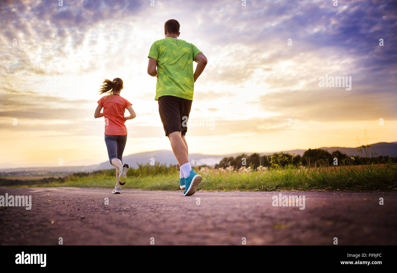 Cross-country trail running people at sunset. Runner couple exercising ...