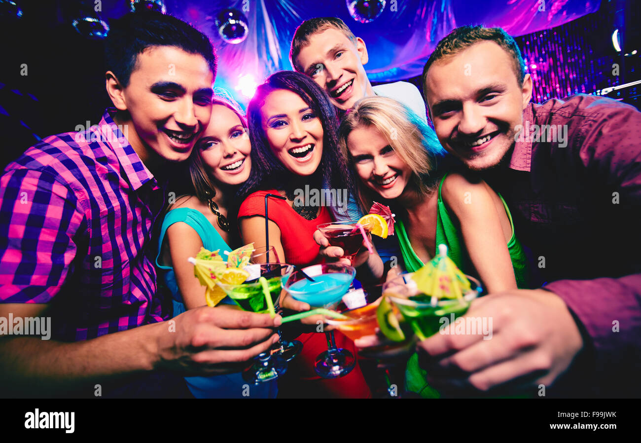 Joyful group of friends toasting with cocktails at party Stock Photo ...
