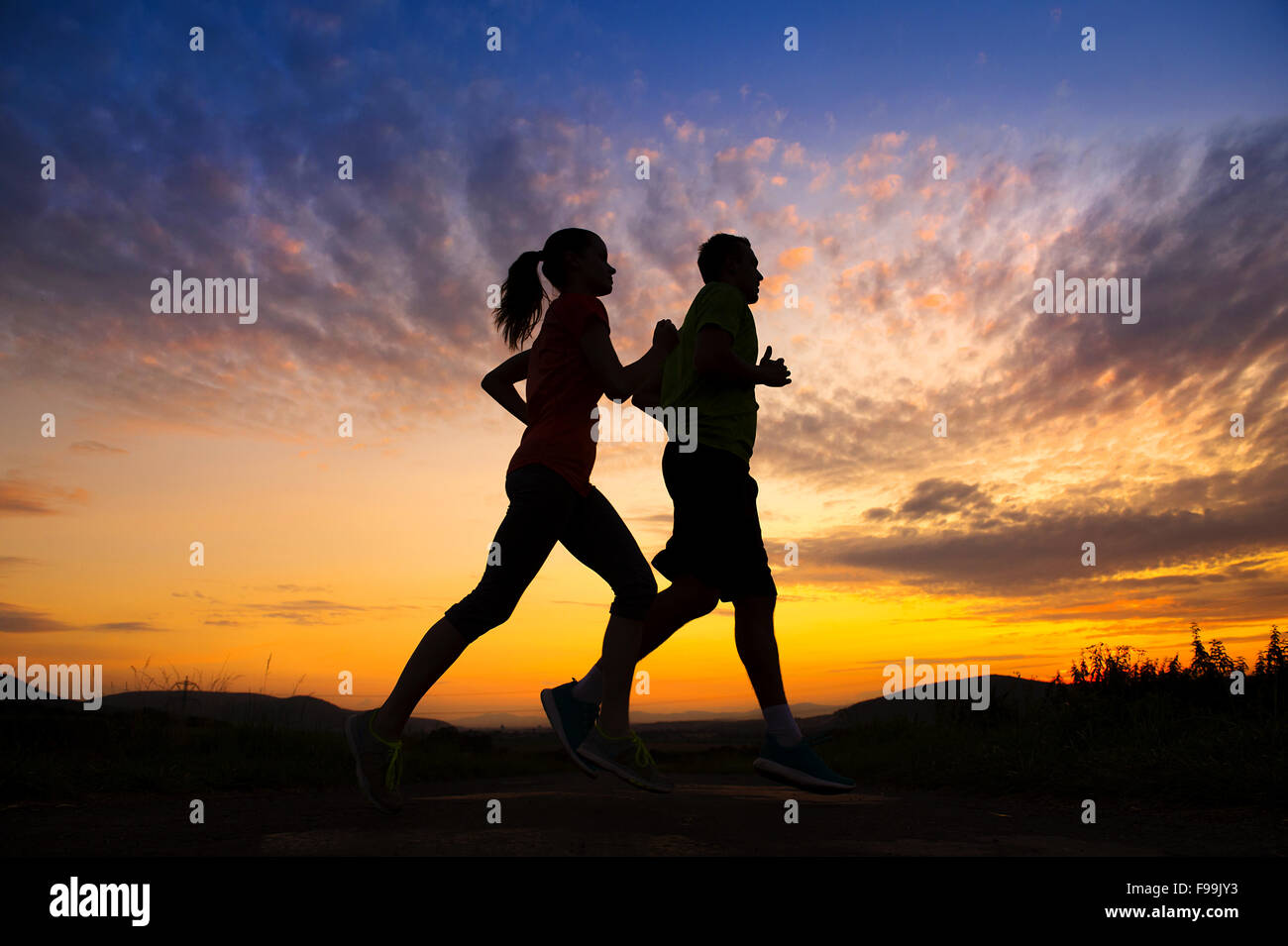 Silhouette of young couple running in sunset Stock Photo - Alamy