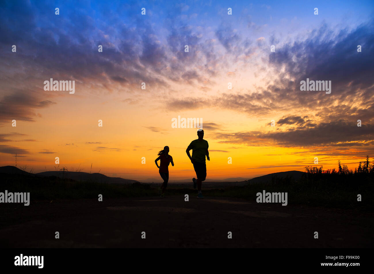 Silhouette of young couple running in sunset Stock Photo - Alamy