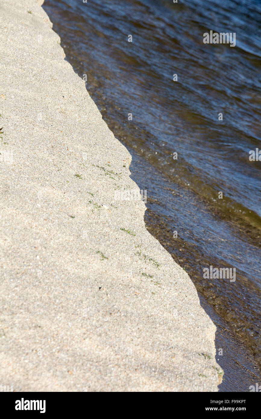 sand and water on the shore of a lake Stock Photo - Alamy