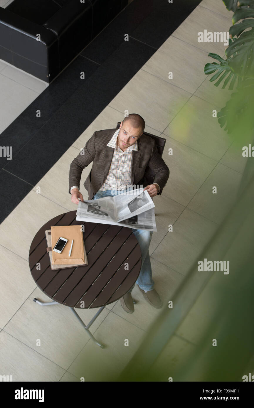 Handsome businessman or manager in office building reading newspaper ...