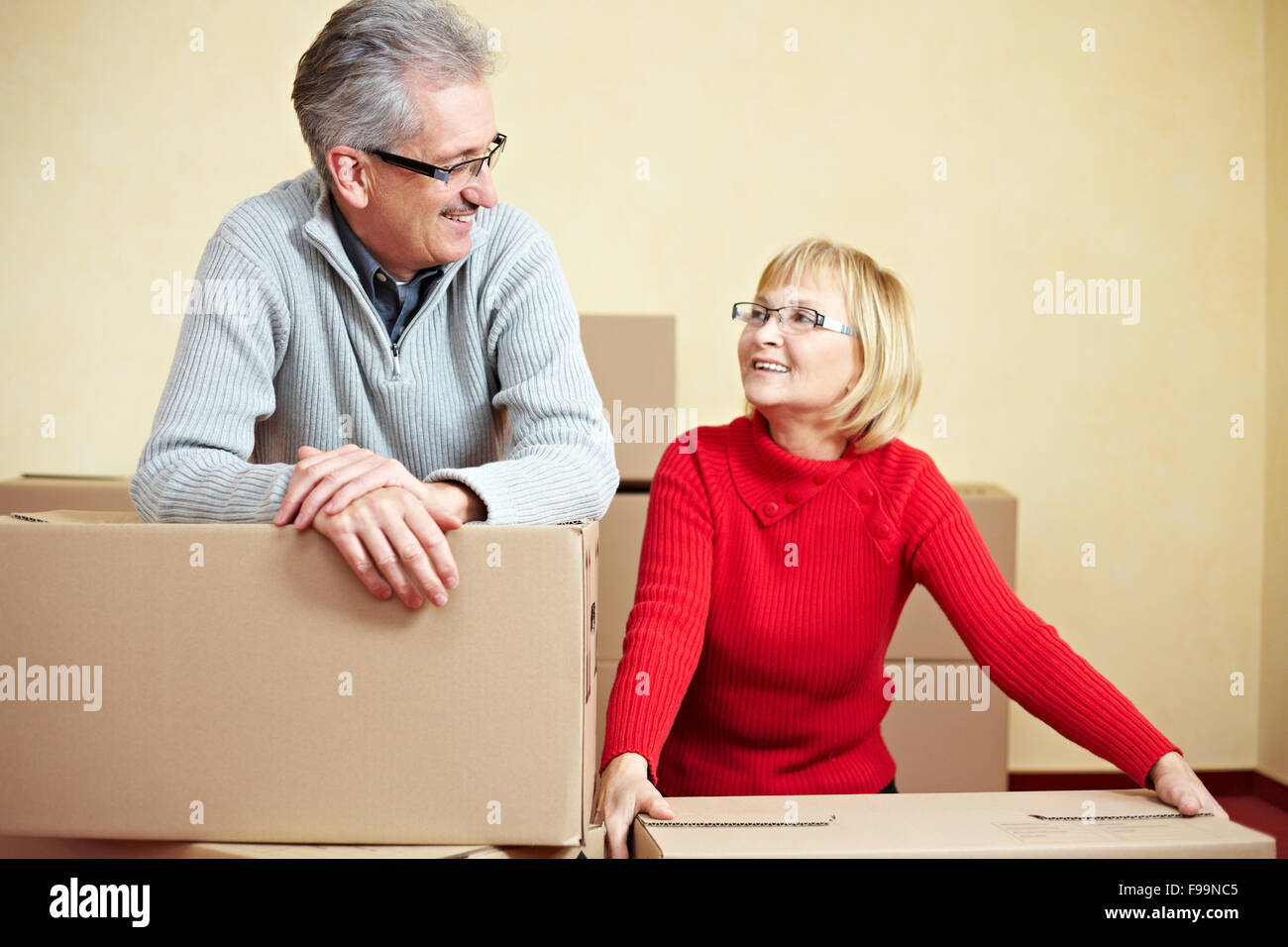 Two happy senior people with many moving boxes Stock Photo - Alamy