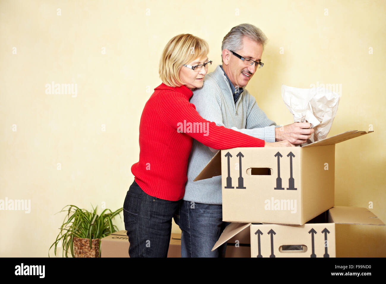 Two senior people searching stuff in a moving box Stock Photo - Alamy