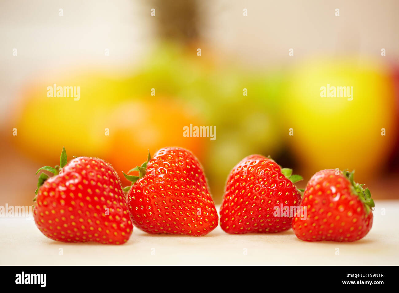Four red strawberries with other fruits in a kitchen Stock Photo - Alamy