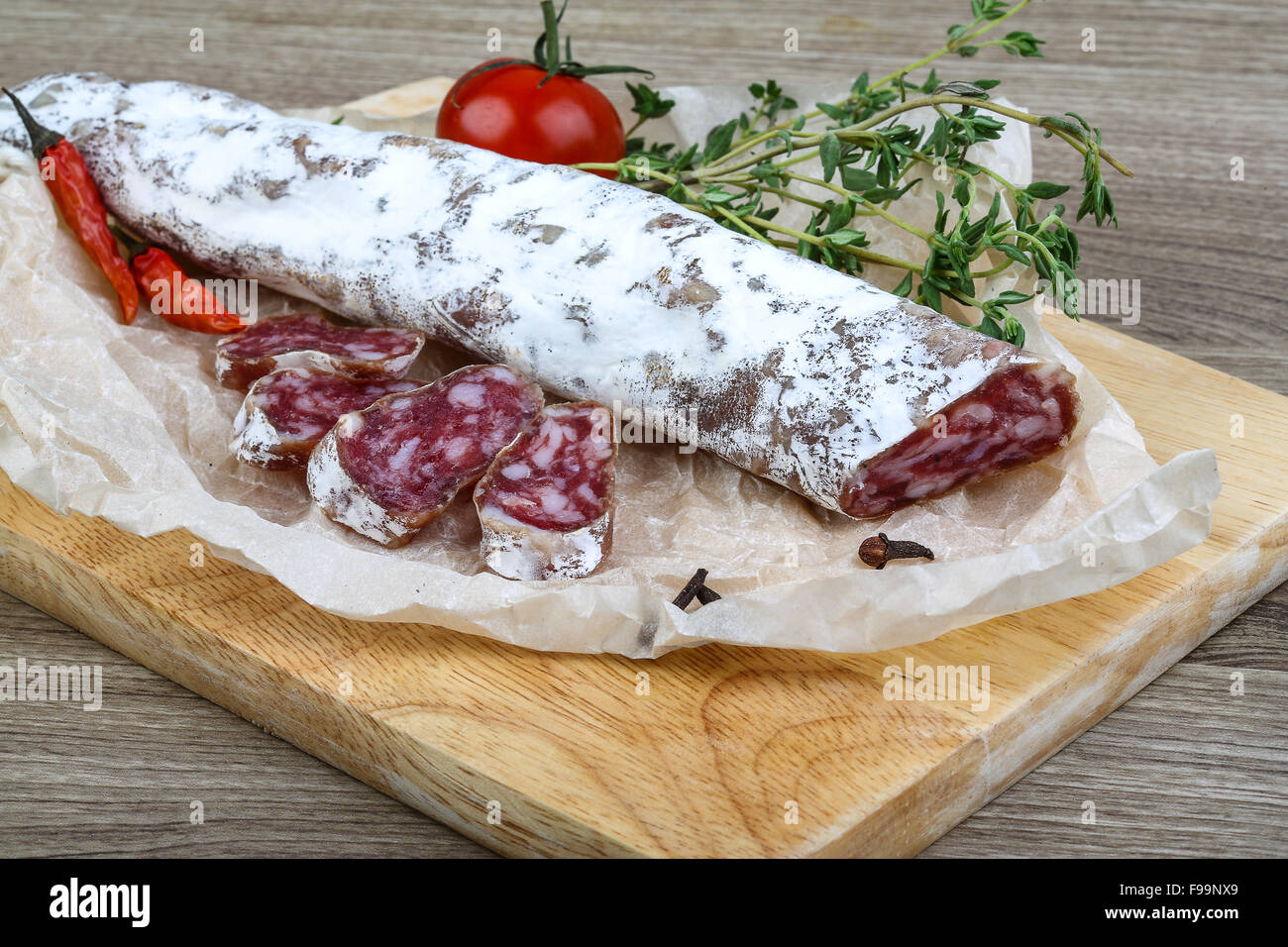 Traditional Spanish sausages- fuet with thyme leaves on the wood ...