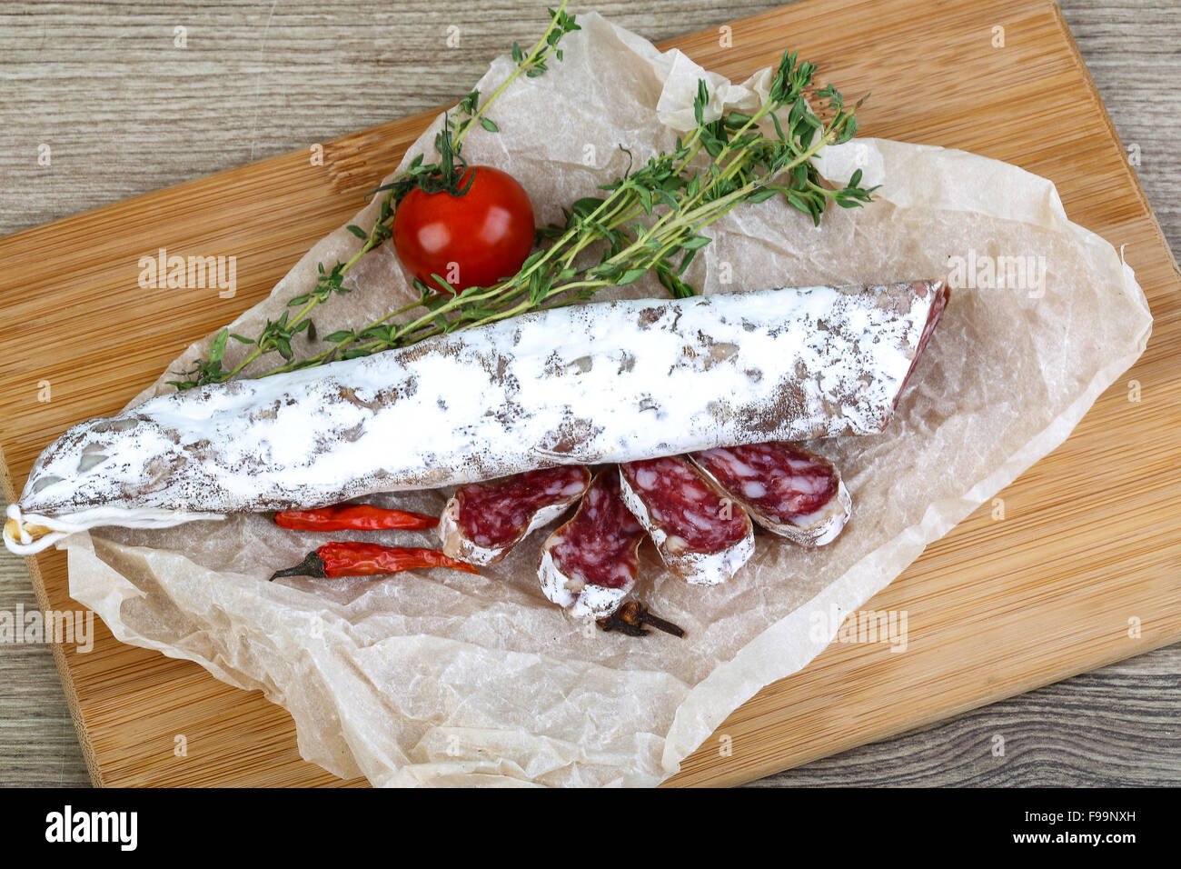 Traditional Spanish sausages- fuet with thyme leaves on the wood ...