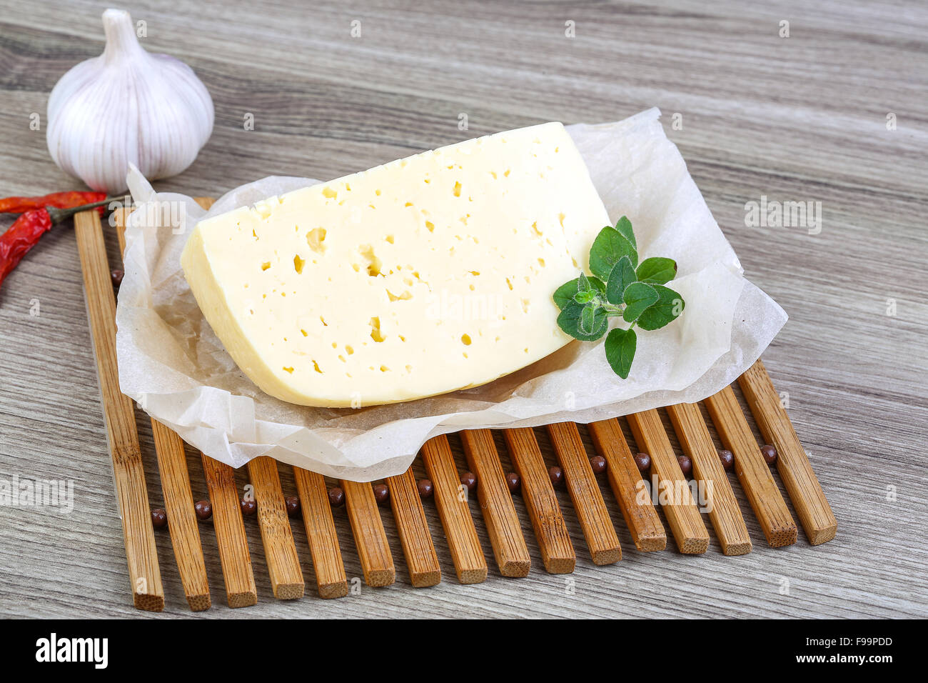 Part of round cheese on the wood background with herbs Stock Photo - Alamy