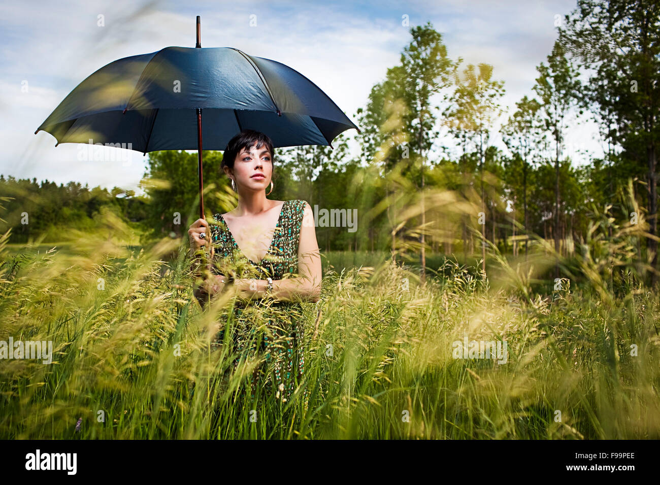 woman holding umbrella in field Stock Photo - Alamy