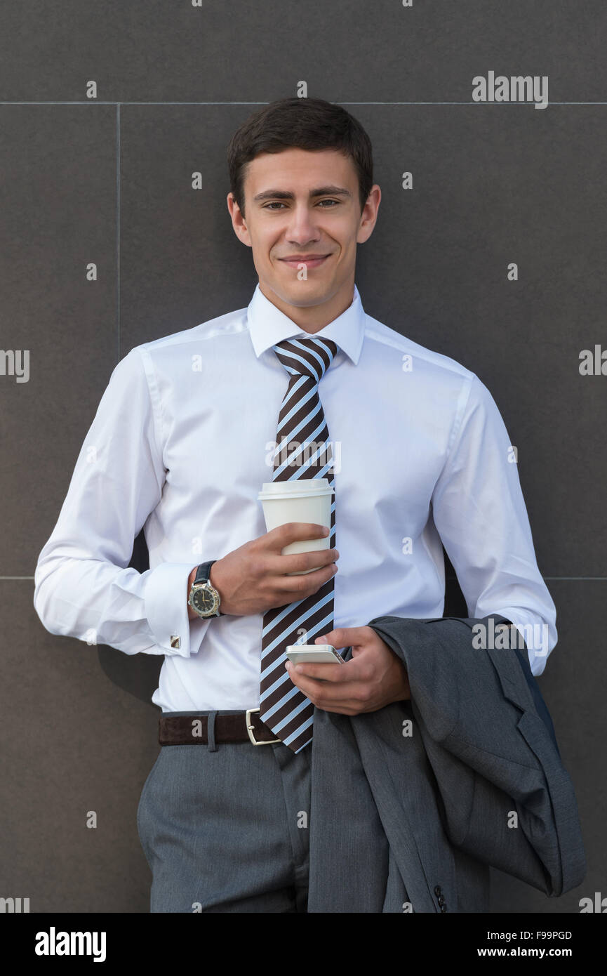Businessman Leaning on Modern Office Building Wall With Coffee Using ...