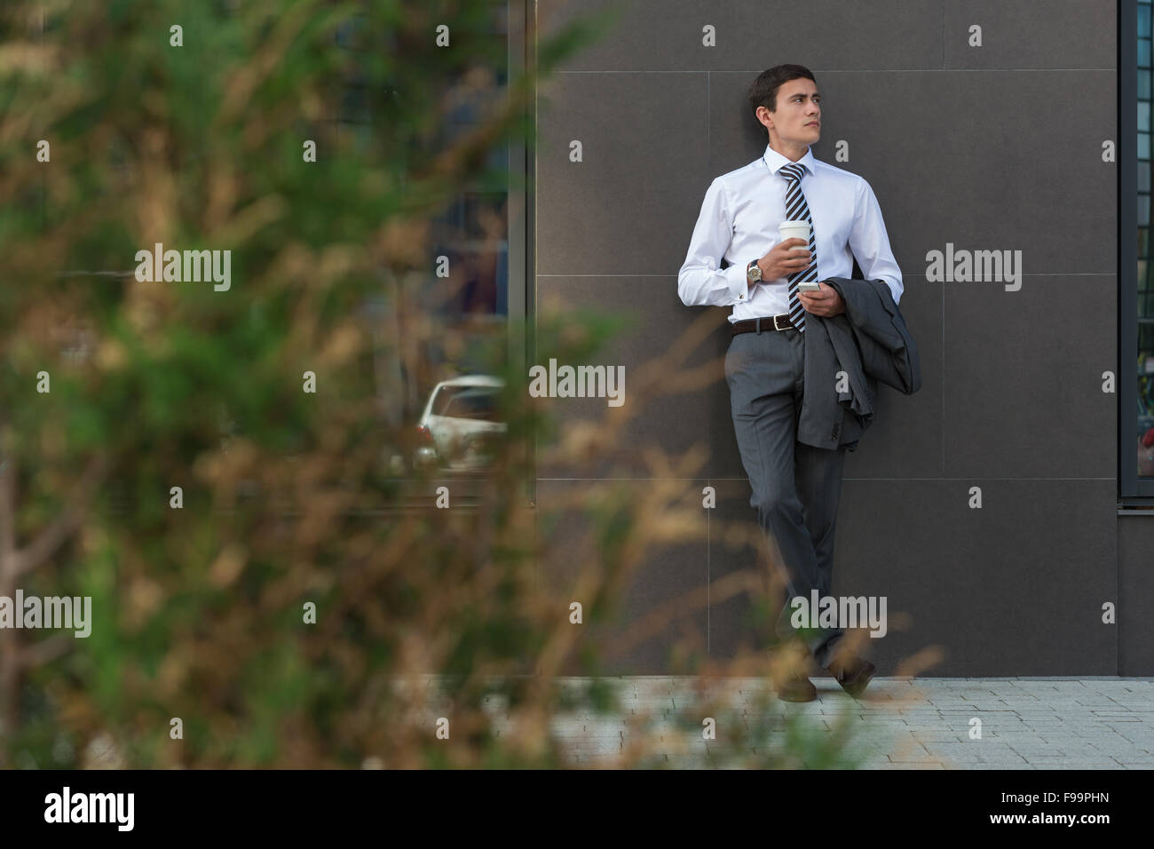 Businessman holding coffee typing on hi-res stock photography and ...