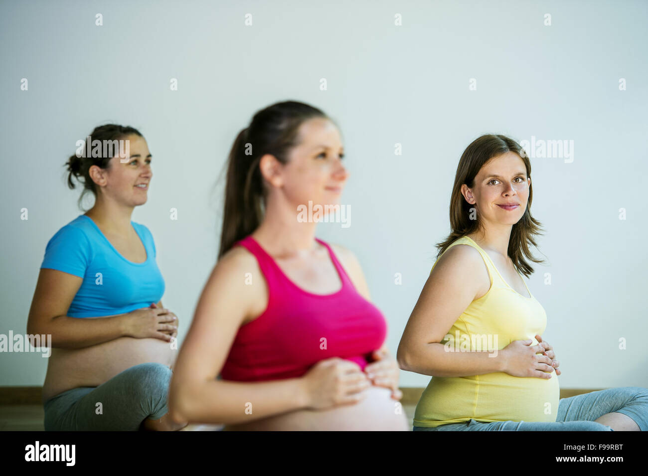 Group of young pregnant women doing relaxation exercise on exercising ...
