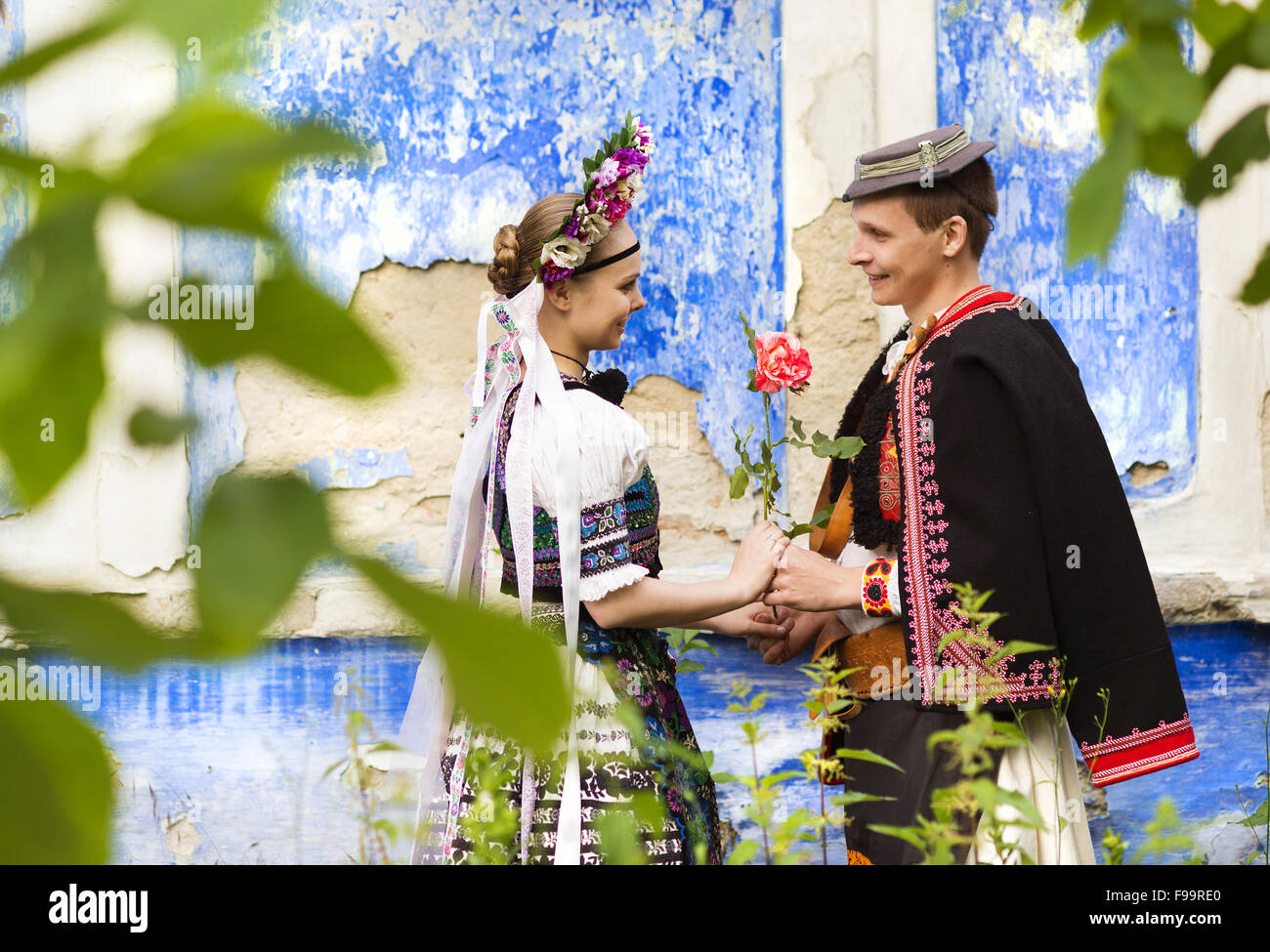 Love couple standing by the blue wall wearing traditional Eastern ...