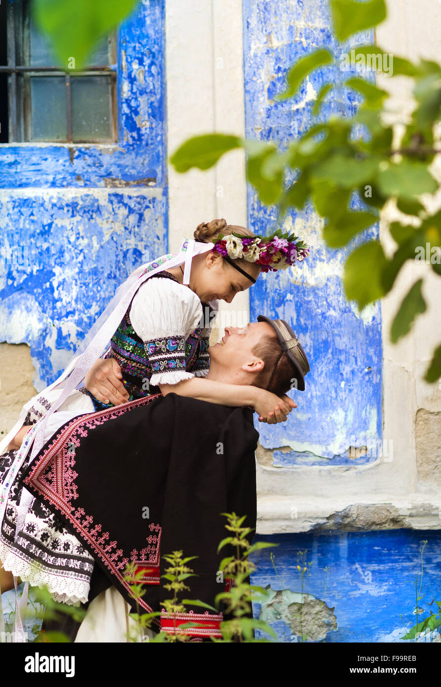 Love couple standing by the blue wall wearing traditional Eastern ...