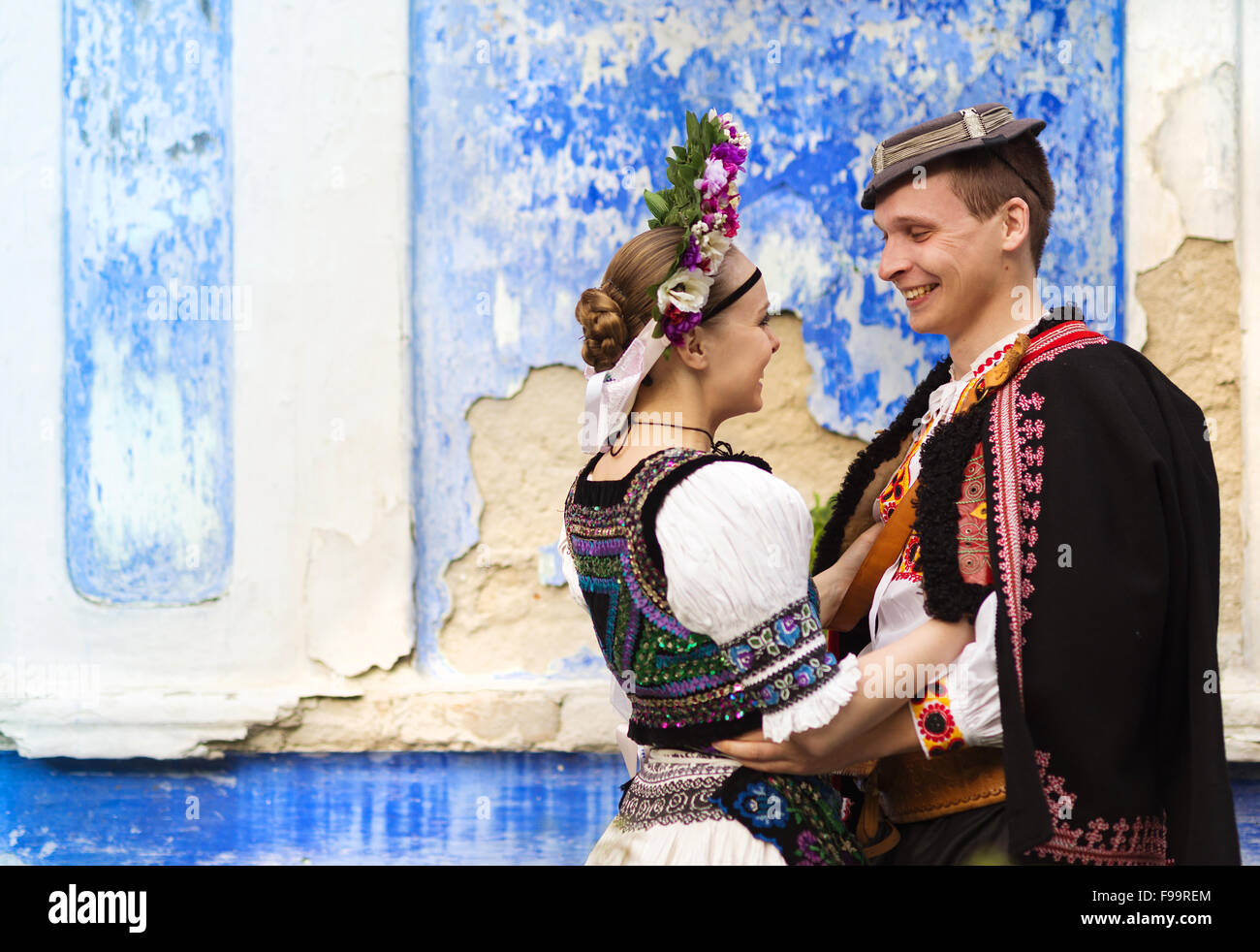 Love couple standing by the blue wall wearing traditional Eastern ...