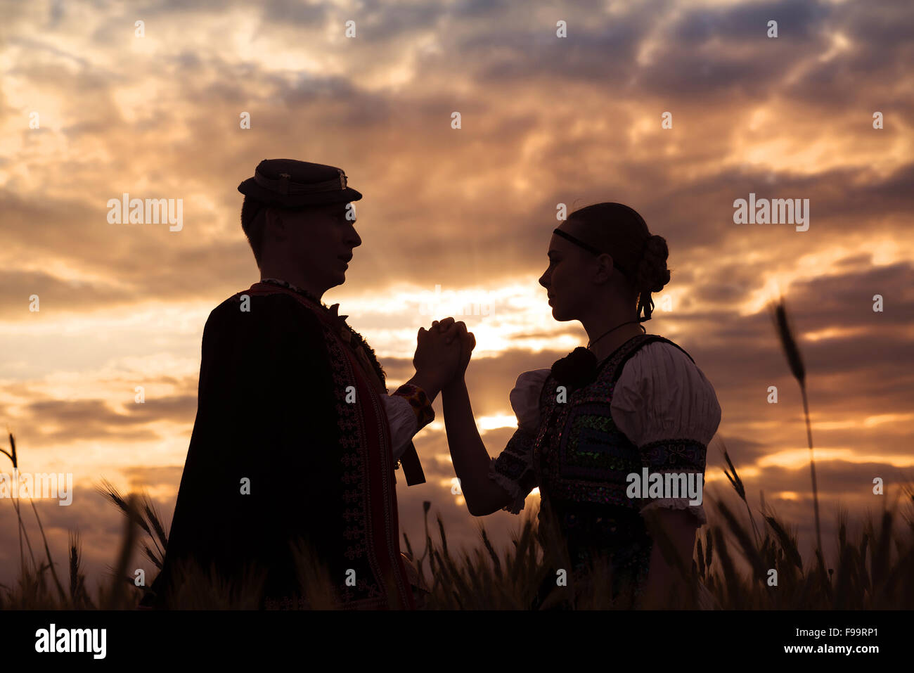 Love couple in sunset field. They wearing traditional Eastern Europe ...