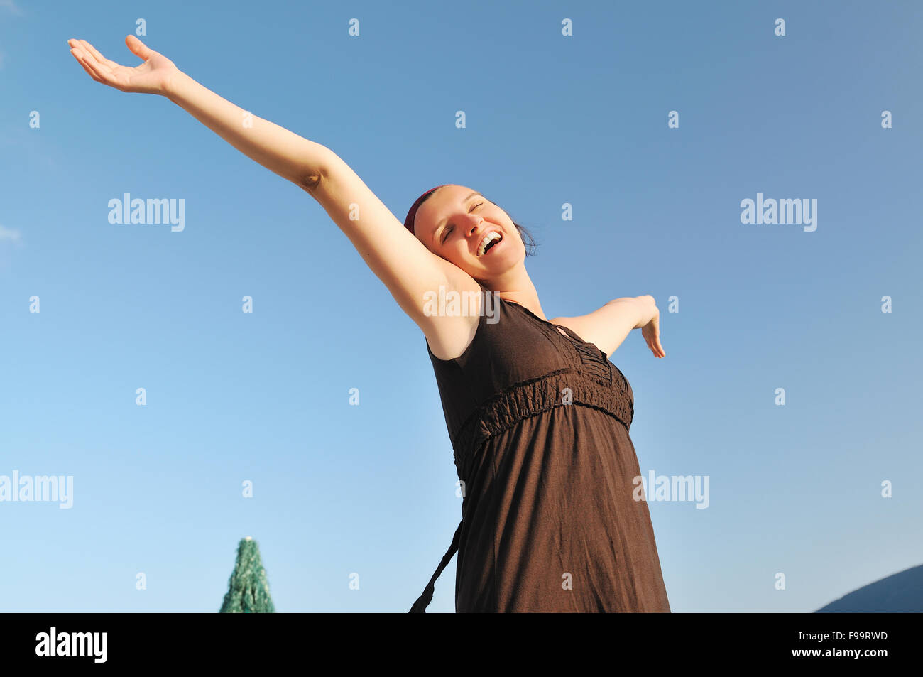 young happy woman with arms wide open representing freedom concept ...