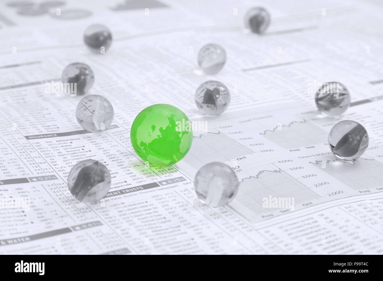 Black and white marbles with a large green marble as the map of Stock ...