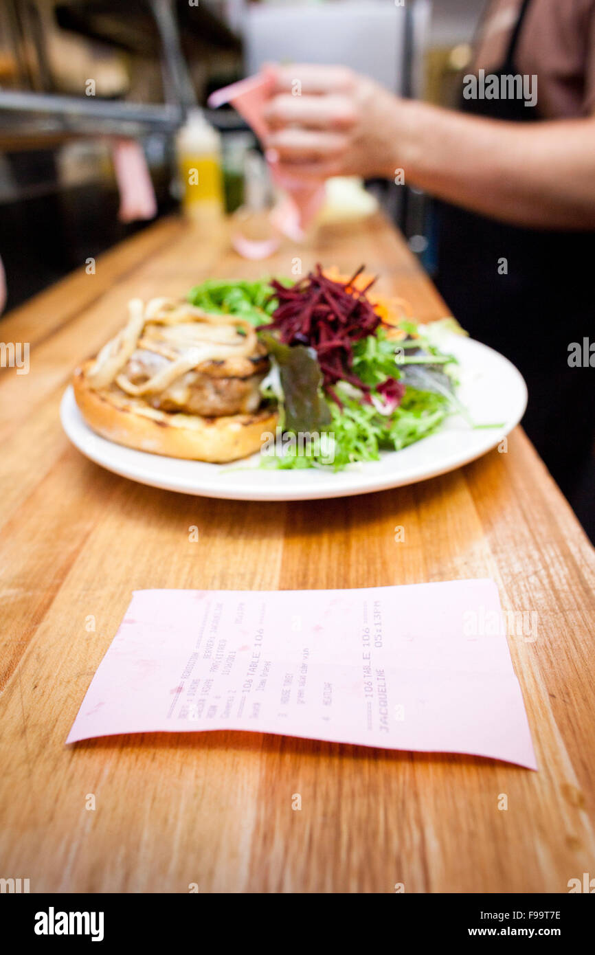 Dinner order ticket with burger and salad on plate Stock Photo - Alamy