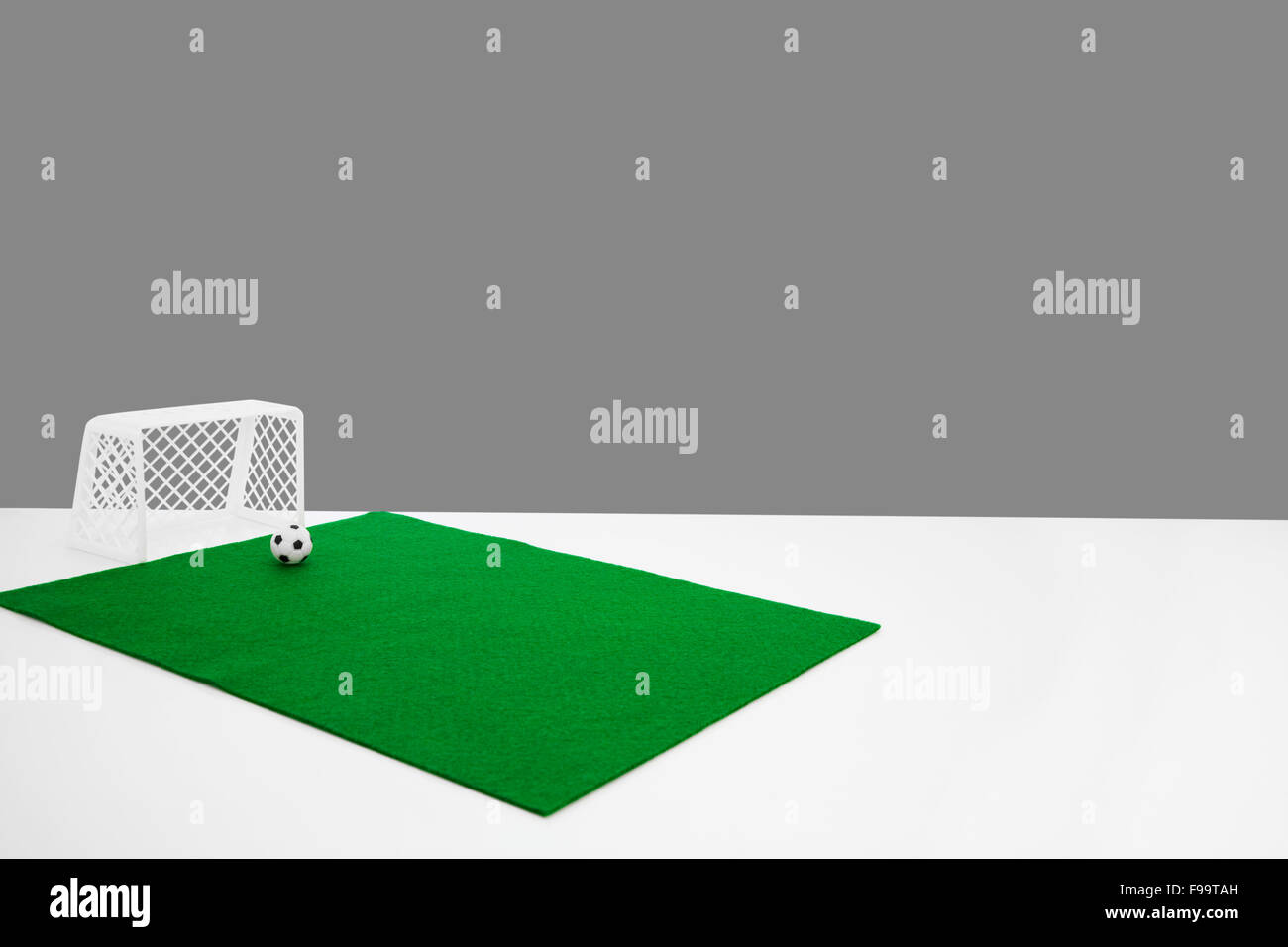 Small table top football goal posts, football and green felt fak Stock ...