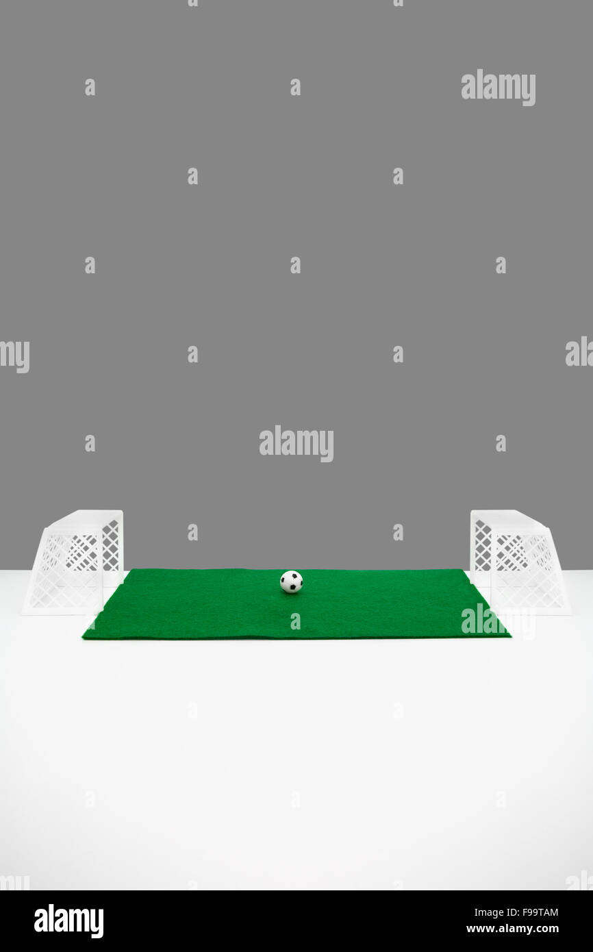 Small table top football goal posts, football and green felt fak Stock ...
