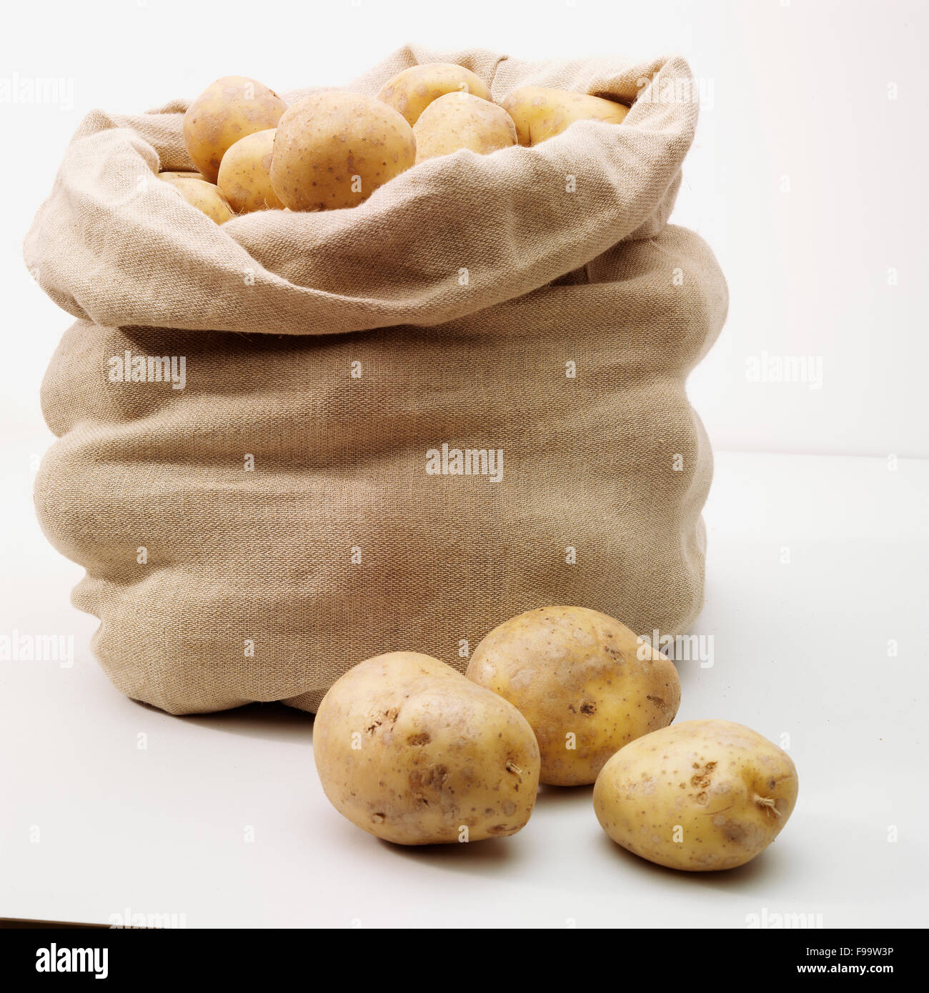 overflowing bag of potatos on whit Stock Photo - Alamy