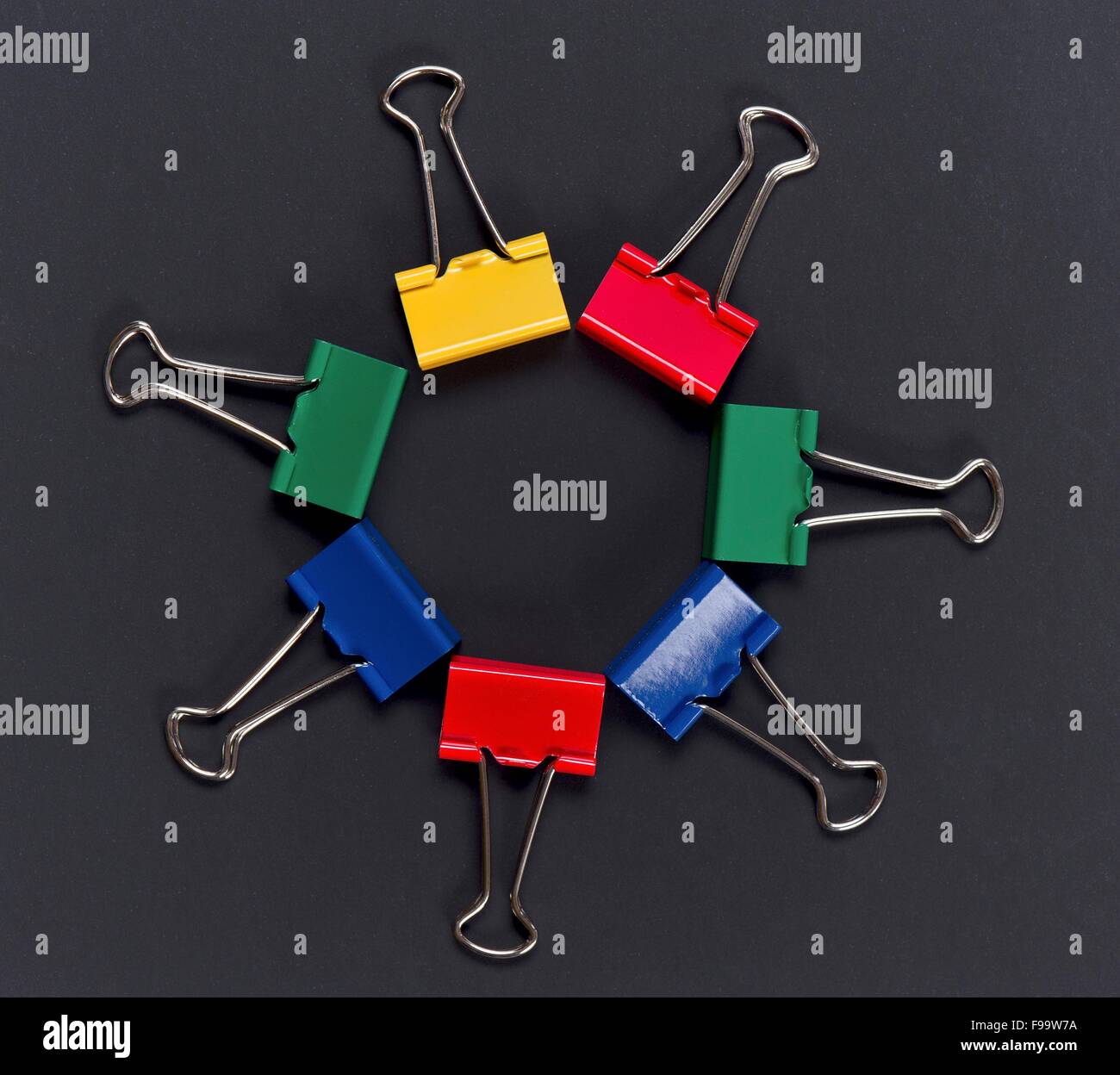 Colored paper clips on a dark background Stock Photo - Alamy