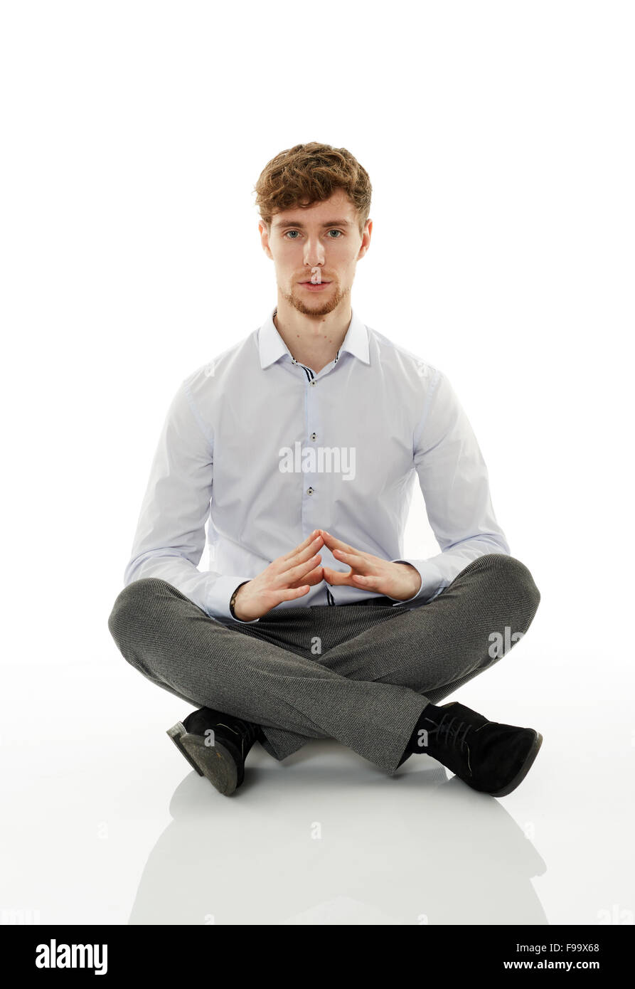 Calm and relaxed businessman meditating, sitting with his legs crossed ...
