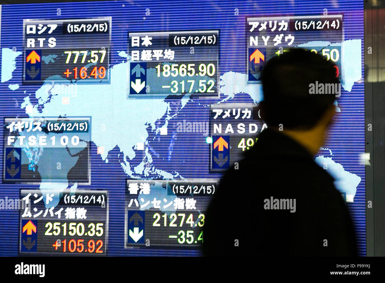 A man walks past an electronic stock board showing Japan's Nikkei Stock ...