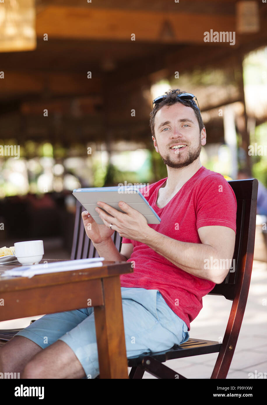 Man smiling tablet beach hi-res stock photography and images - Alamy