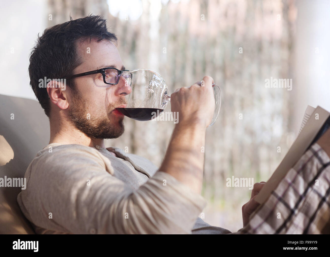 Young handsome man relaxing, reading book and drinking red wine Stock ...