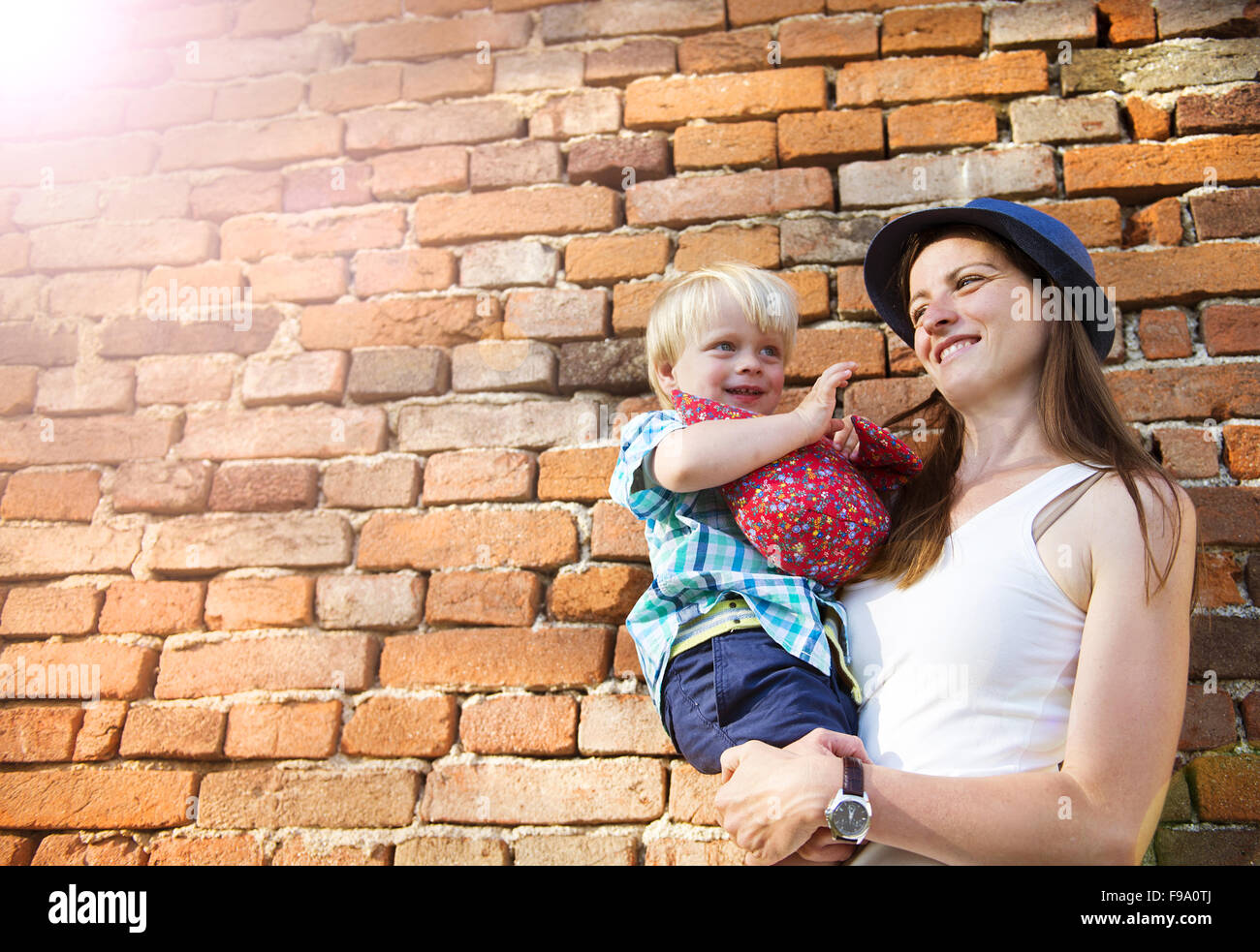 Mother and son hugging by the brick wall in countryside Stock Photo - Alamy