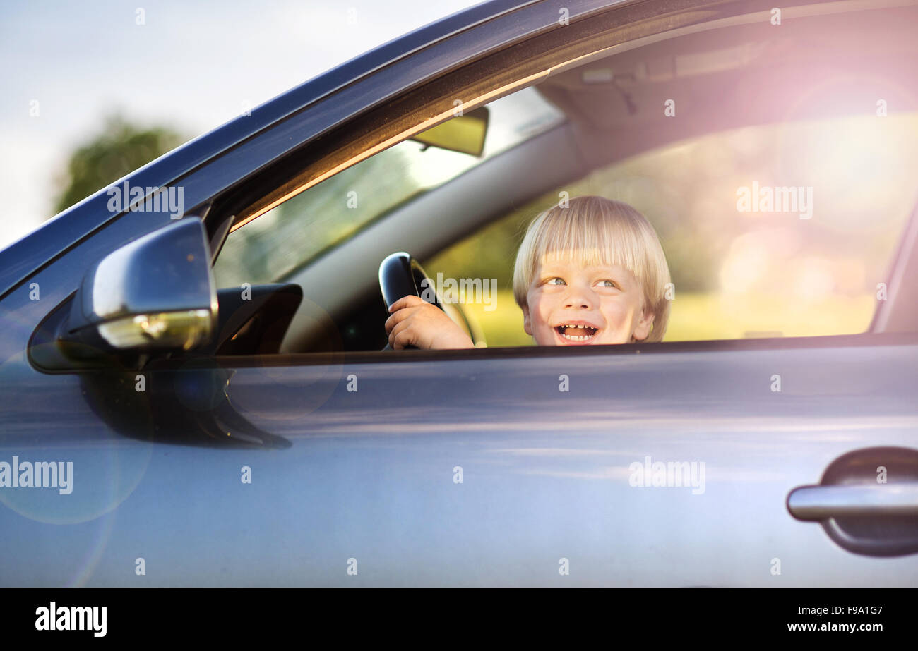 Little boy driving a car. He is having fun Stock Photo - Alamy